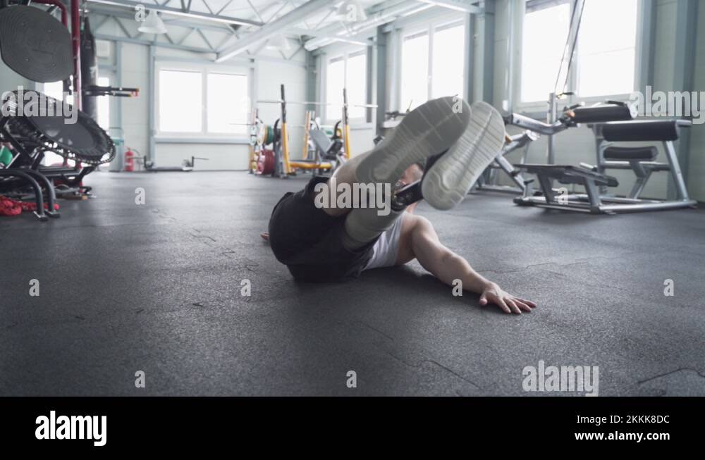 Man with prosthetic leg doing abs exercises on the gym floor to ...