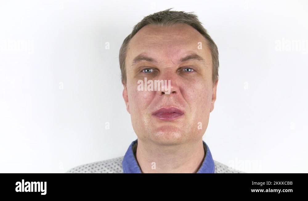 A portrait of a man who was hit in the face by a fish. He grimaces into ...