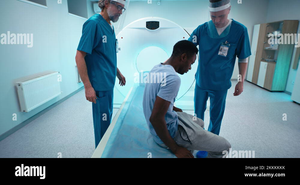 Male doctors making CT scan to African American man in hospital Stock ...