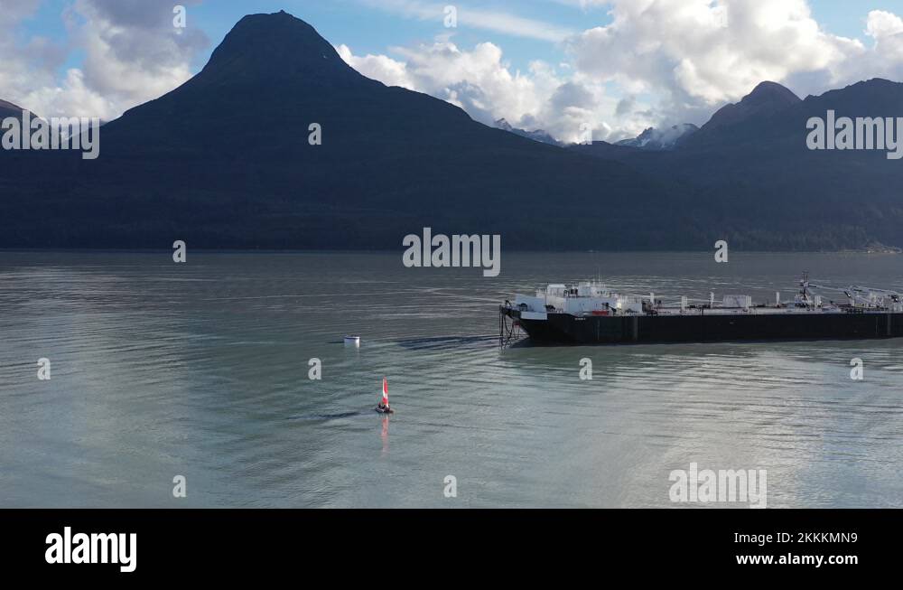 Tiny inflatable sailing raft explores the ocean waters around a giant ...