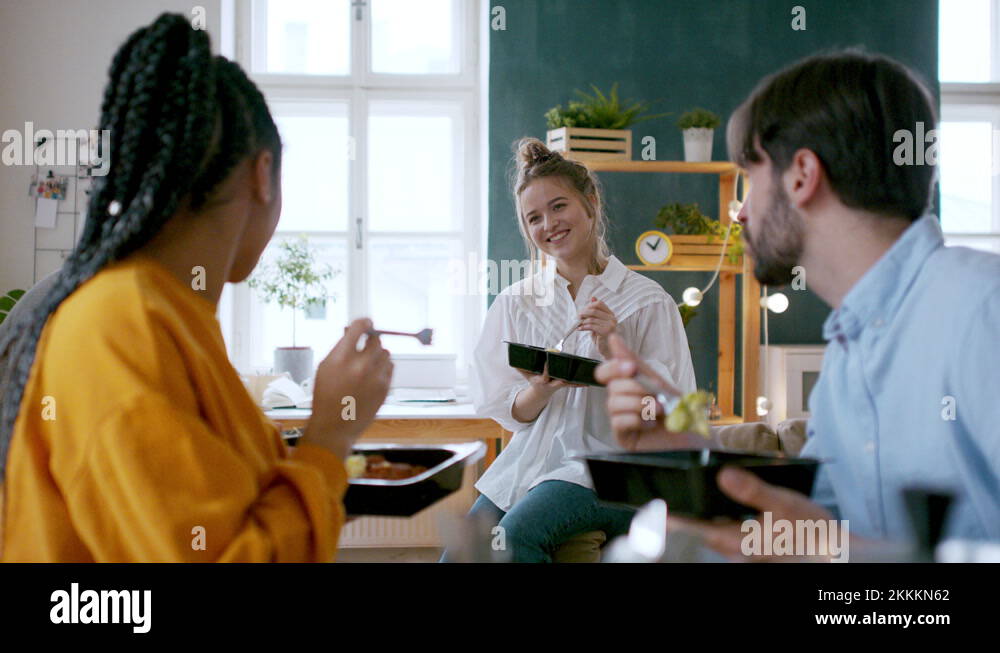 Group of friends eating take away food indoors, food delivery and house ...