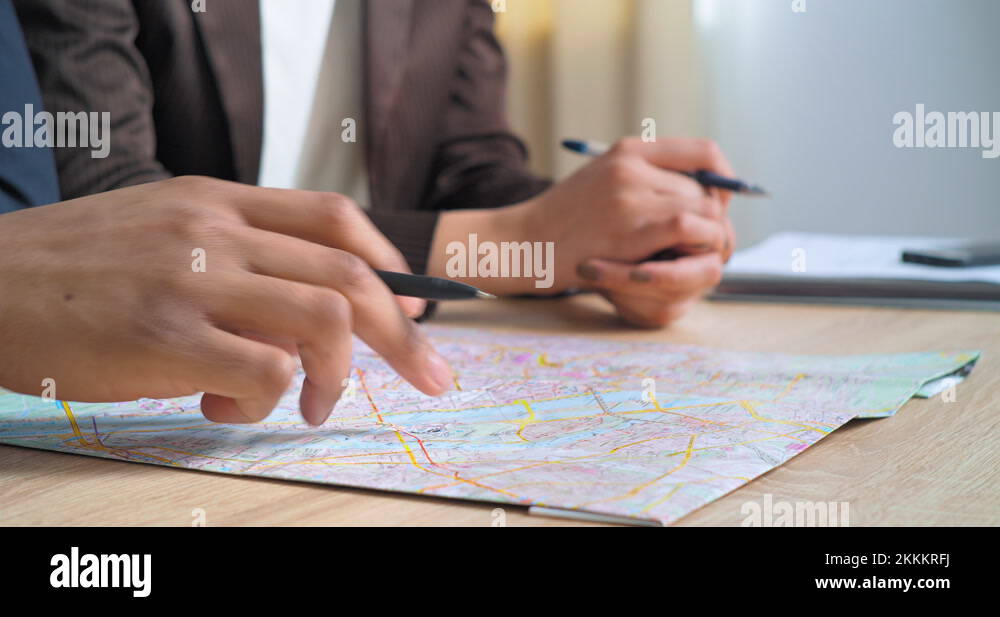 Close-up male and female hands holding pens and world map in office two ...
