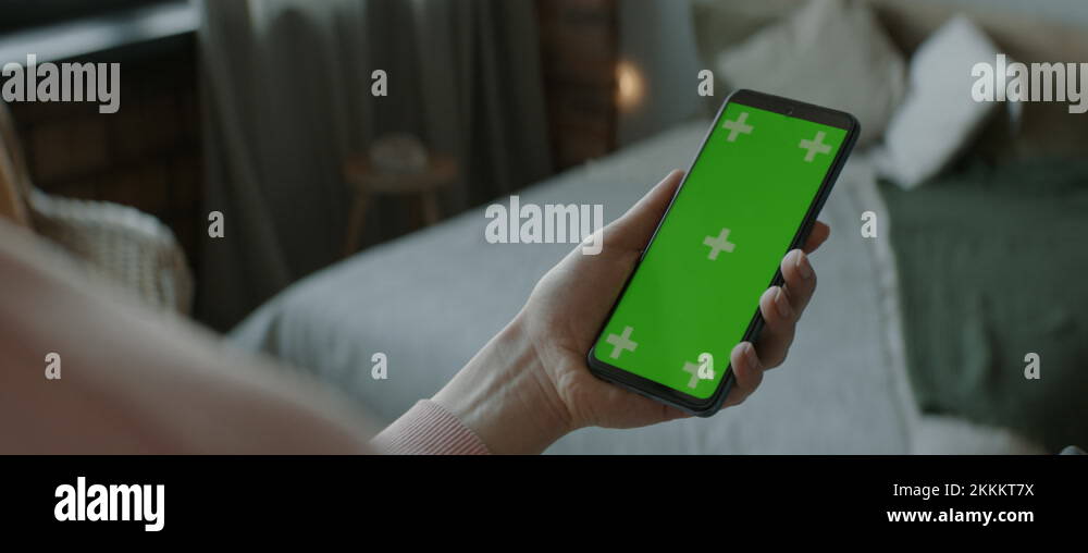 GREEN SCREEN CHROMA KEY Caucasian female using her phone, scrolling and ...