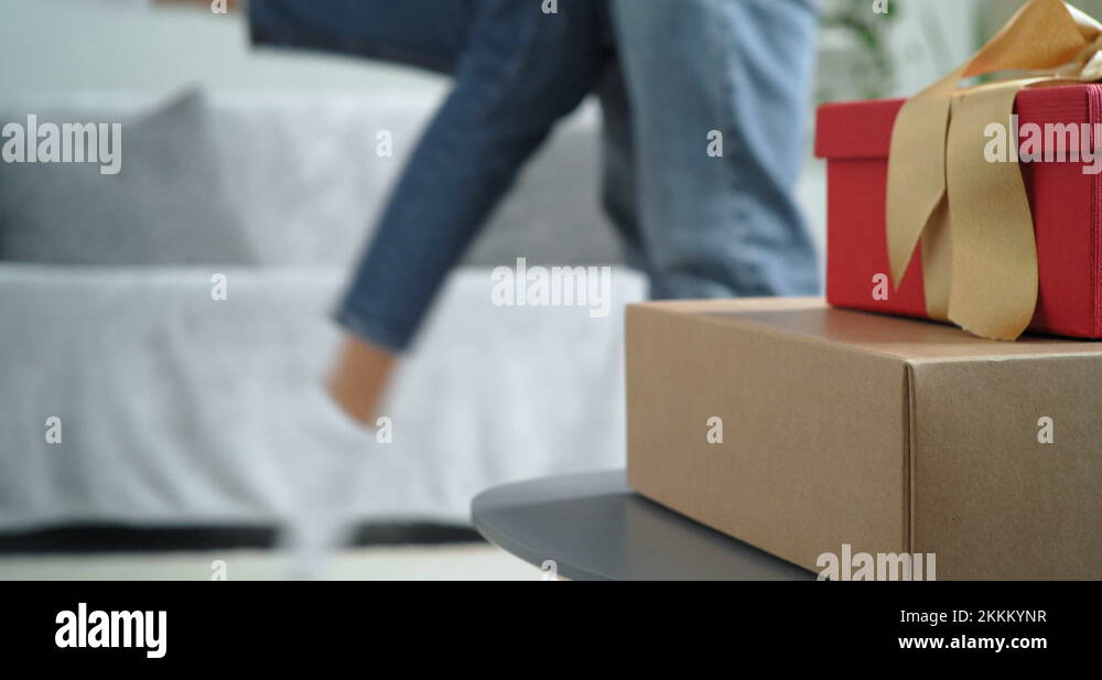 Close-up gift boxes lie on table partners spouses hugging wife hanging ...