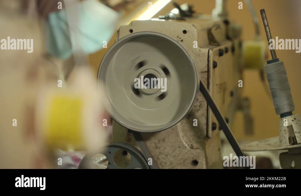 Rotating wheel on a white sewing machine with small belt to transmit ...