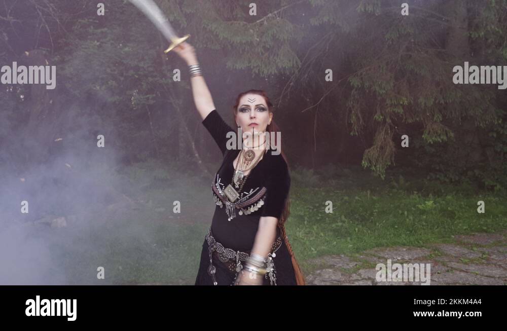 Girl dancing with two swords, turns around. Red smoke. Runes on hand ...