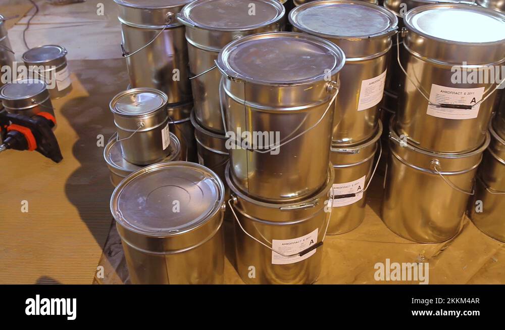 Metal drums at a construction site. Shiny barrels with self-leveling ...