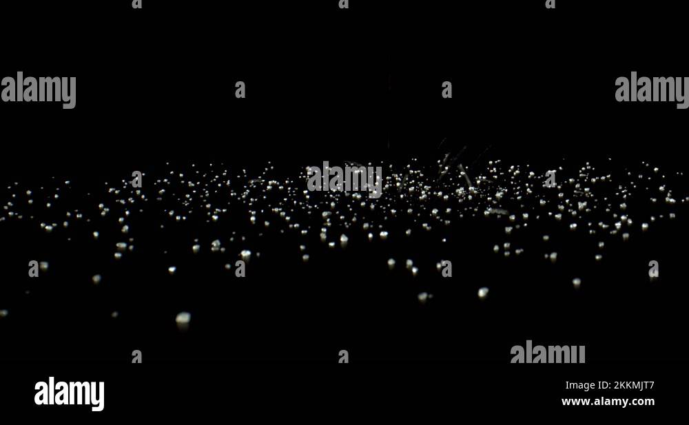 Sugar crystals falling on a black surface, close-up or Powder granules ...