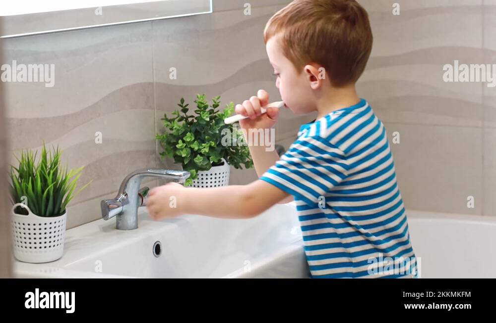 little boy he cleans his teeth, regulates the water, opens the tap ...