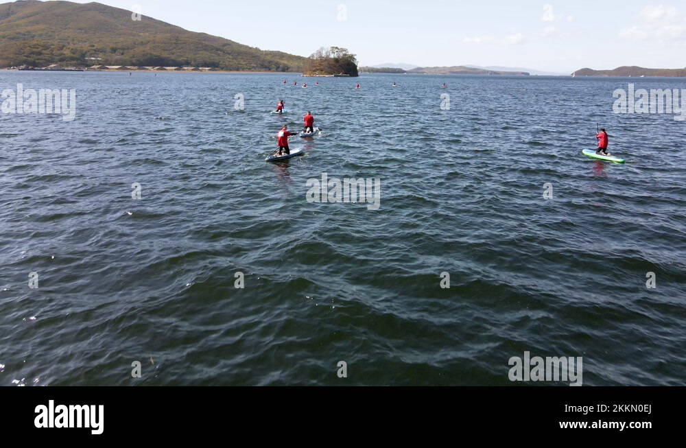 A group of young people ride glanders in the waters of Russky Island ...