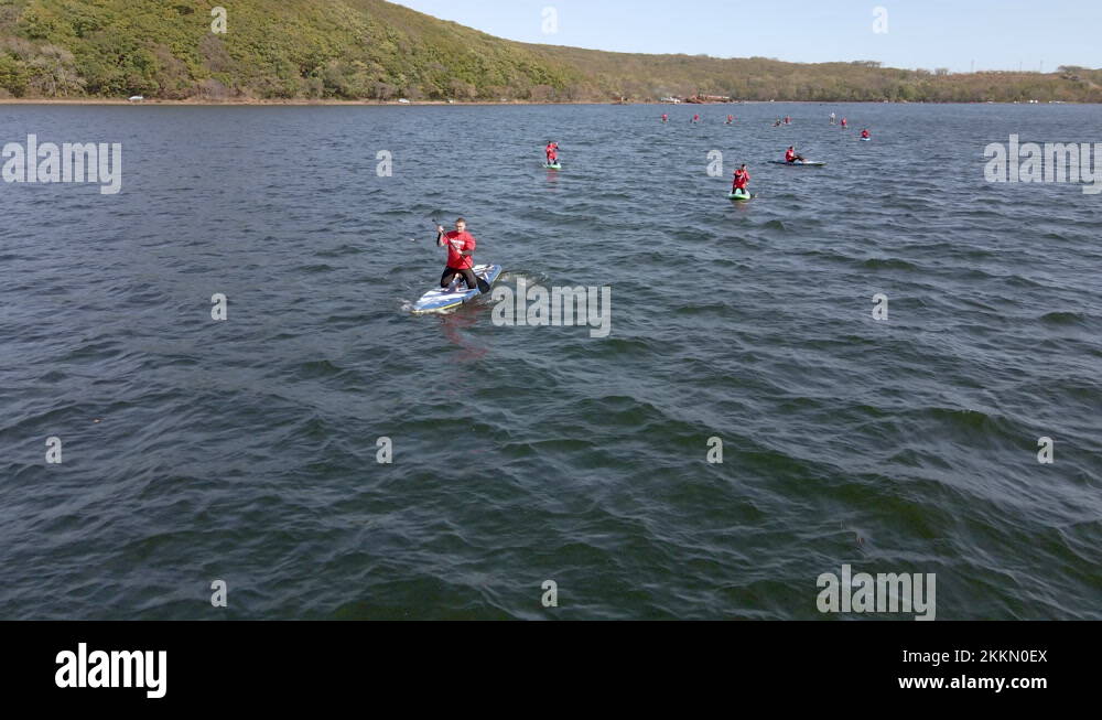 A group of young people ride glanders in the waters of Russky Island ...