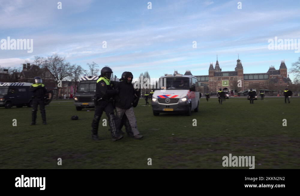 Dutch riot police officers arrest demonstrator at lockdown protest ...