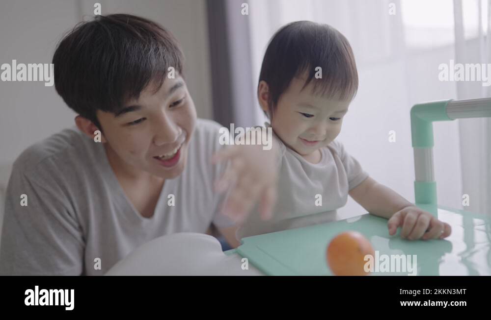 Father and active daughter sliding down a ball on slider, family time ...