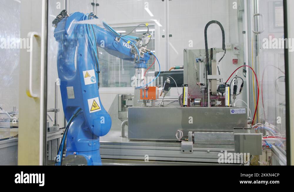 Robotic line at a manufacturing facility. Robot placing metal parts ...