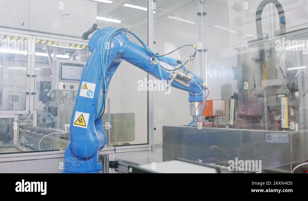 Robotic line at a manufacturing facility. Robot placing metal parts ...