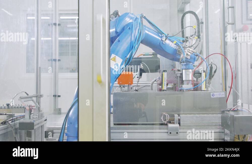 Robotic line at a manufacturing facility. Robot placing metal parts ...