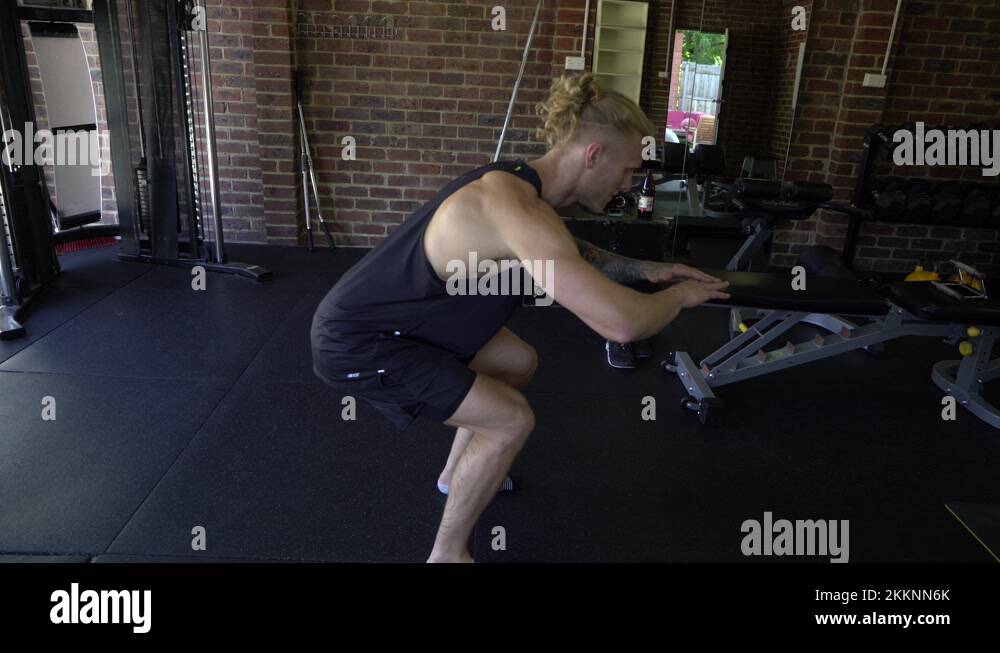 Tattoo man muscles in home gym squat to lunge Stock Video Footage - Alamy