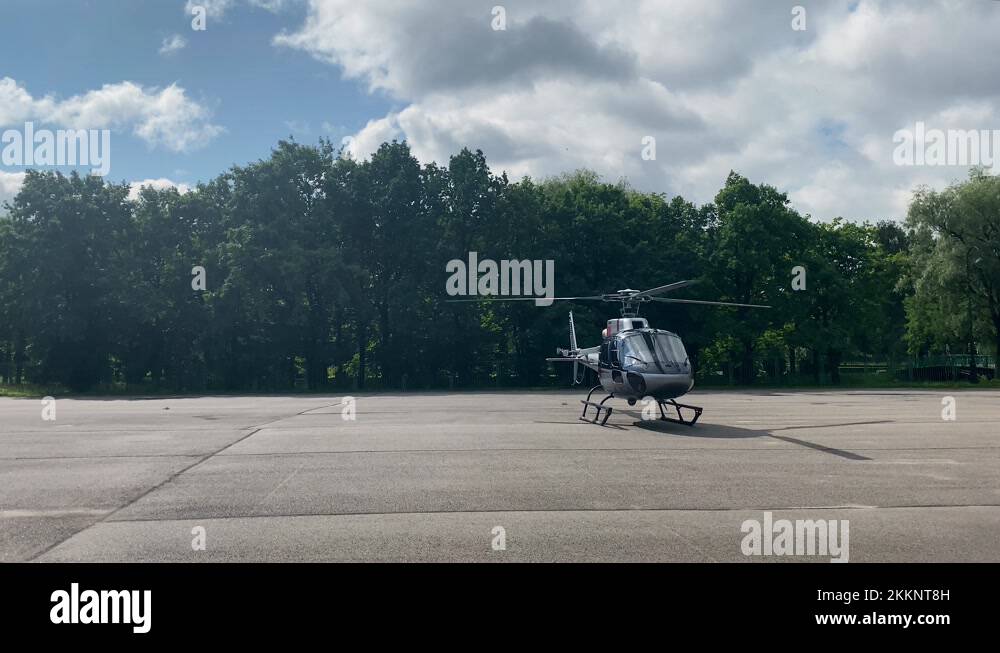 a small private helicopter on a large concrete take-off pad with ...
