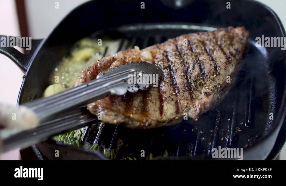Rib eye steak fried on hot pan 4K. Chef is flipping beef steak Stock ...