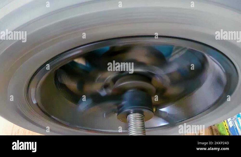 Close up front view of car wheel spinning on digital wheel balancing ...