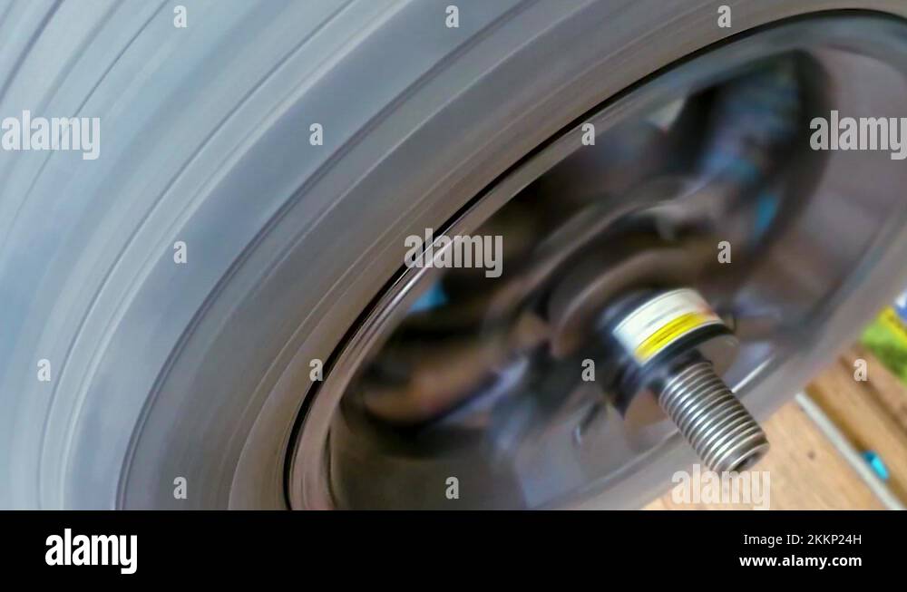 Side view showing mechanic inspecting the imbalance on car wheel ...