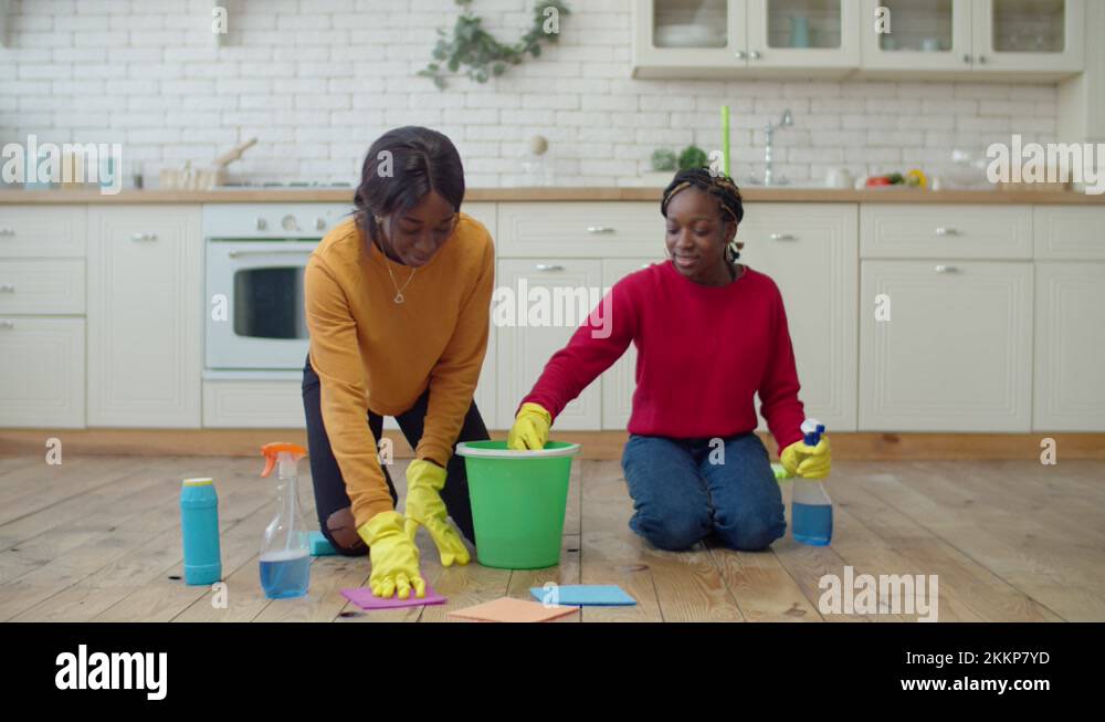 Positive black teenage girls cleaning up floor together Stock Video ...
