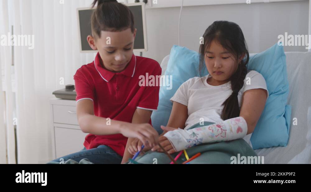 Mixed-race preteen boy visiting asian girl friend in hospital painting ...