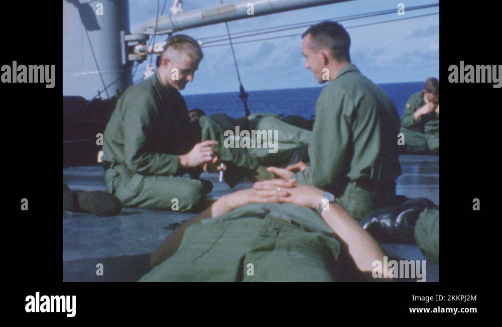 1960s: Soldiers playing game of cards on deck. Silhouette of soldier ...