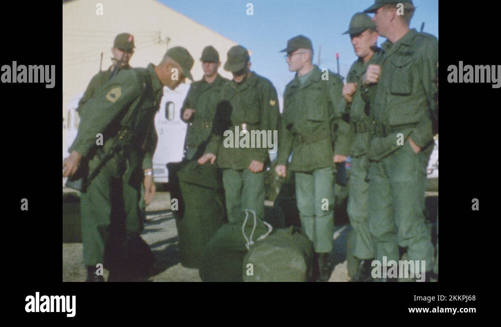 1960s: Officer checks soldier's bags. Officer inspects soldier's rifles ...