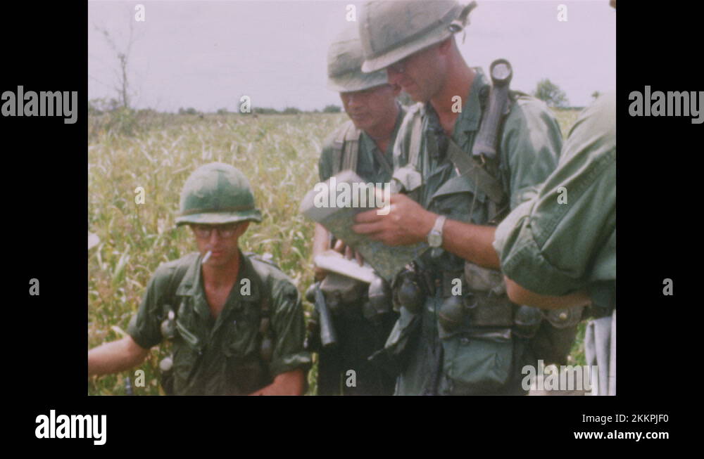 1960s: Soldiers in field, look at map while talking. Soldiers walk ...