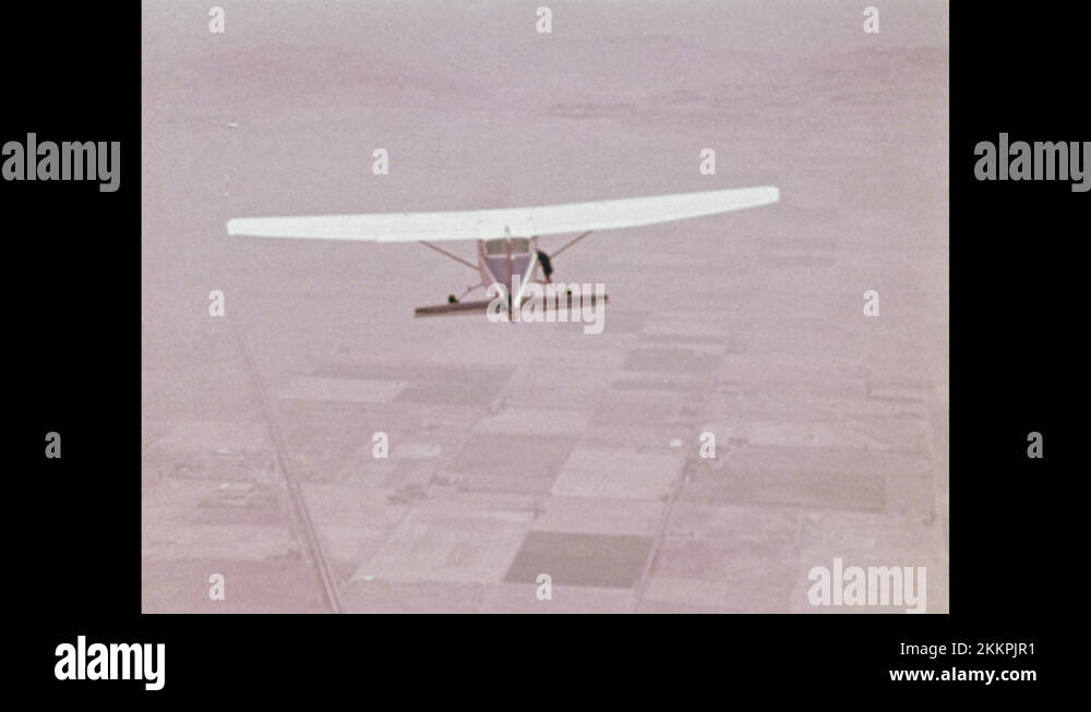 1970s: Sky-diving airplane flies through the air, a man slowly crawls ...