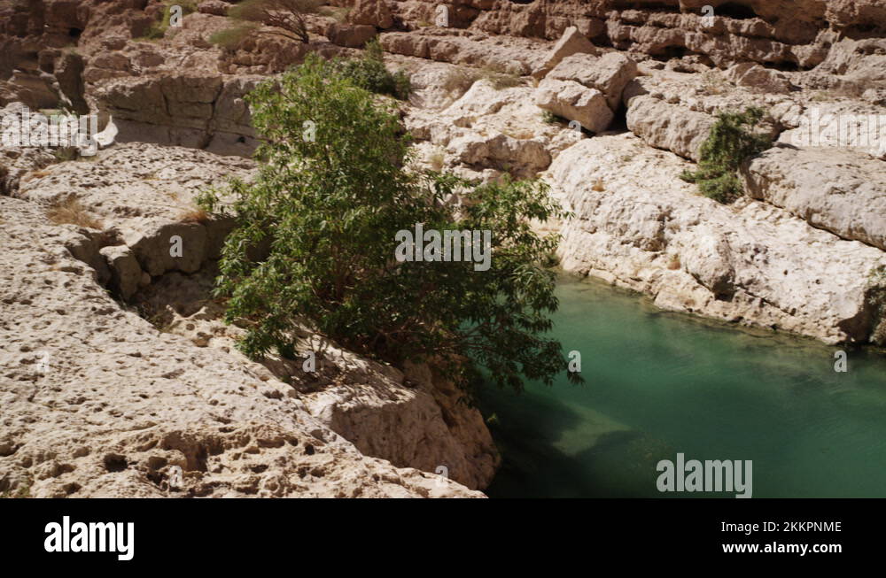The turquoise pools of Wadi Shab canyon in Oman, wide shot pan left ...