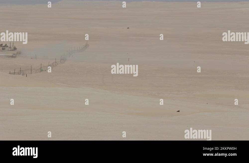 US Army Abrams battle tank passing through barbed wire desert in UAE ...