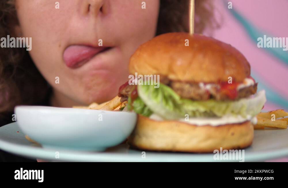 Close up of hungry girl licks her lips in front of a vegan burger Stock ...
