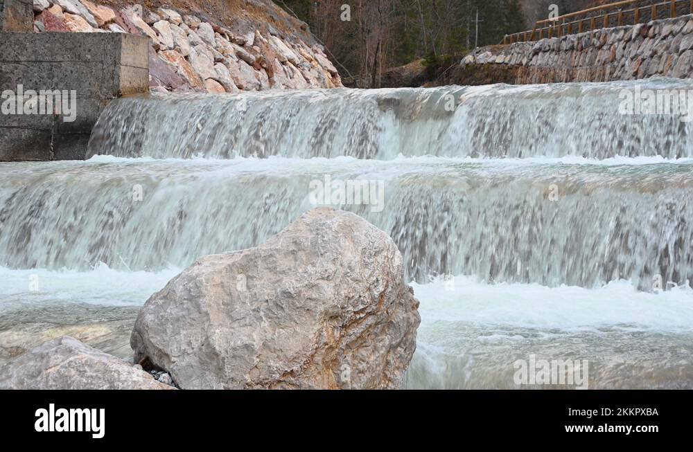 Water flowing over man made cascades in Alps mountains Stock Video ...