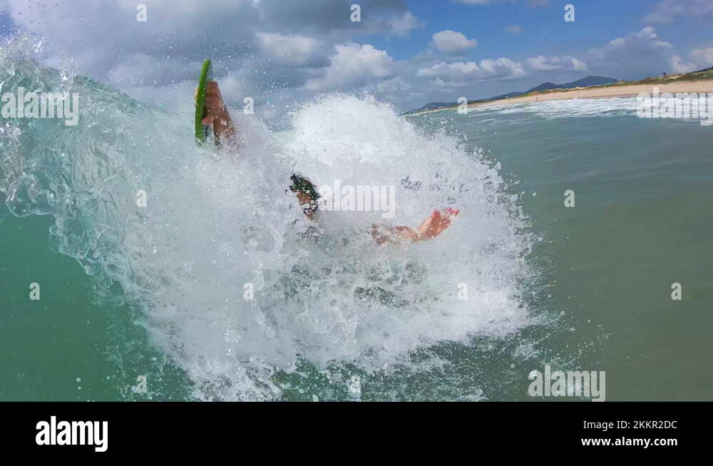 Bodysurfing with handboard, handplane. Young man rides the ocean wave ...