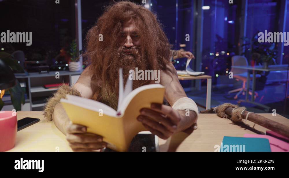 In modern office savage caveman reading a journal screaming and yelling ...