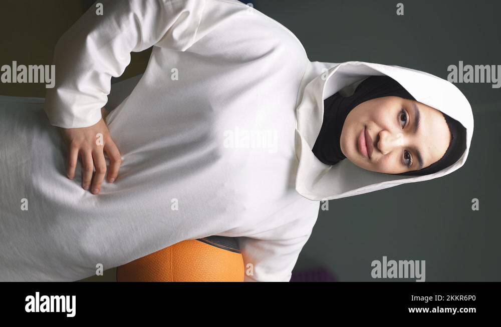Arab athlete with a ball in his hands, a Muslim woman ready to play ...