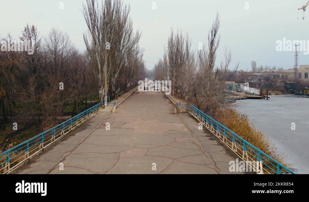 Frozen river with melting ice in winter and pedestrian bridge with ...