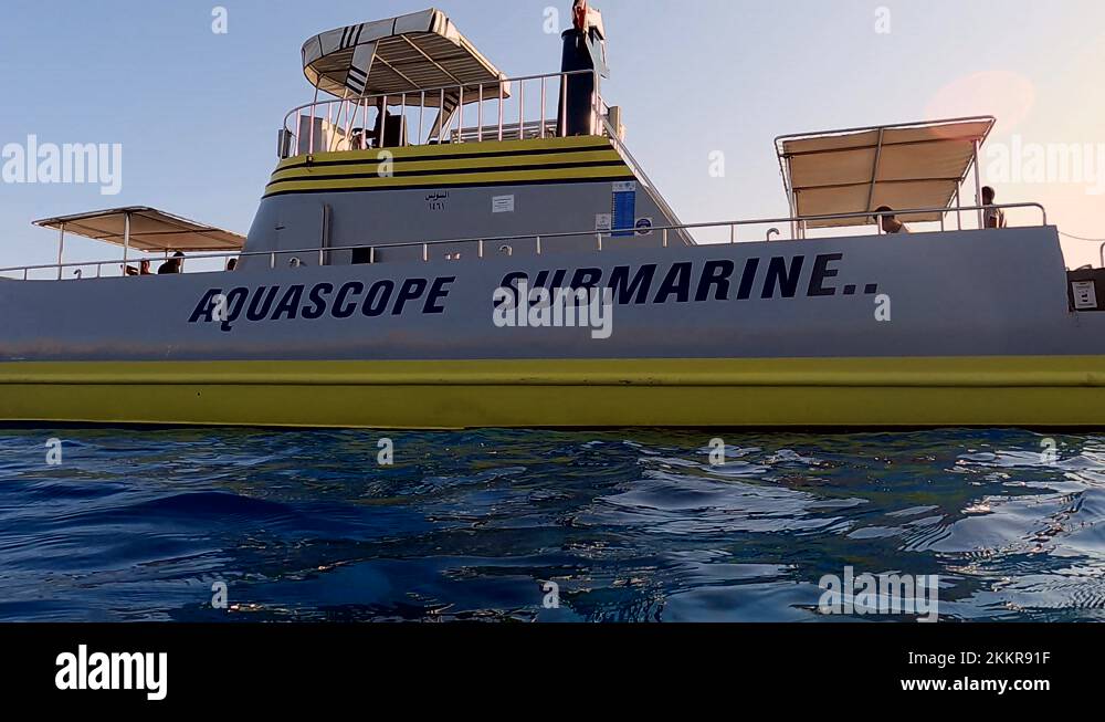 Aquascope submarine with tourists on board swim in blue water ...