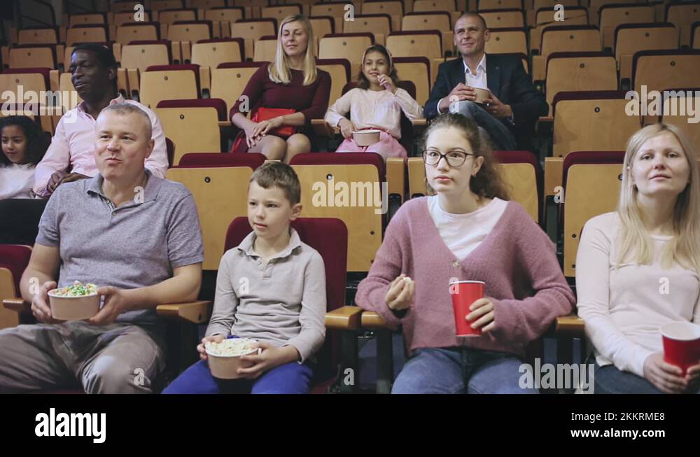 Cheerful people of different ages and nationalities sitting in movie ...