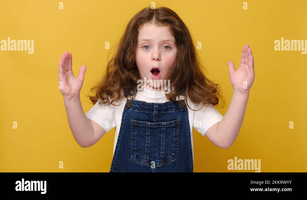 Shocked cute little girl gesturing with hands showing big and large ...