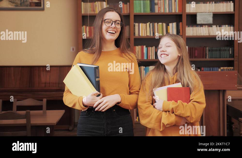 Girls in library walk through the library while laughing concept of ...