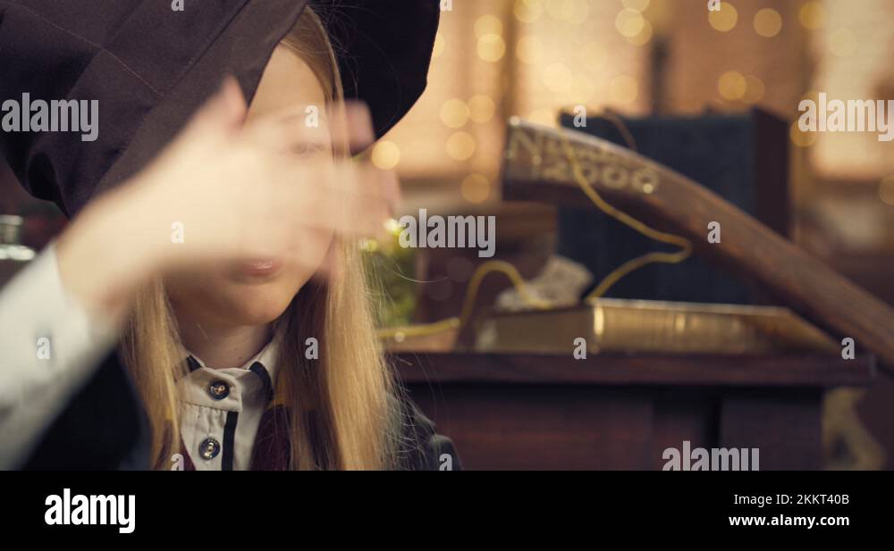 Portrait of a student of magic school taking off the wizard hat ...