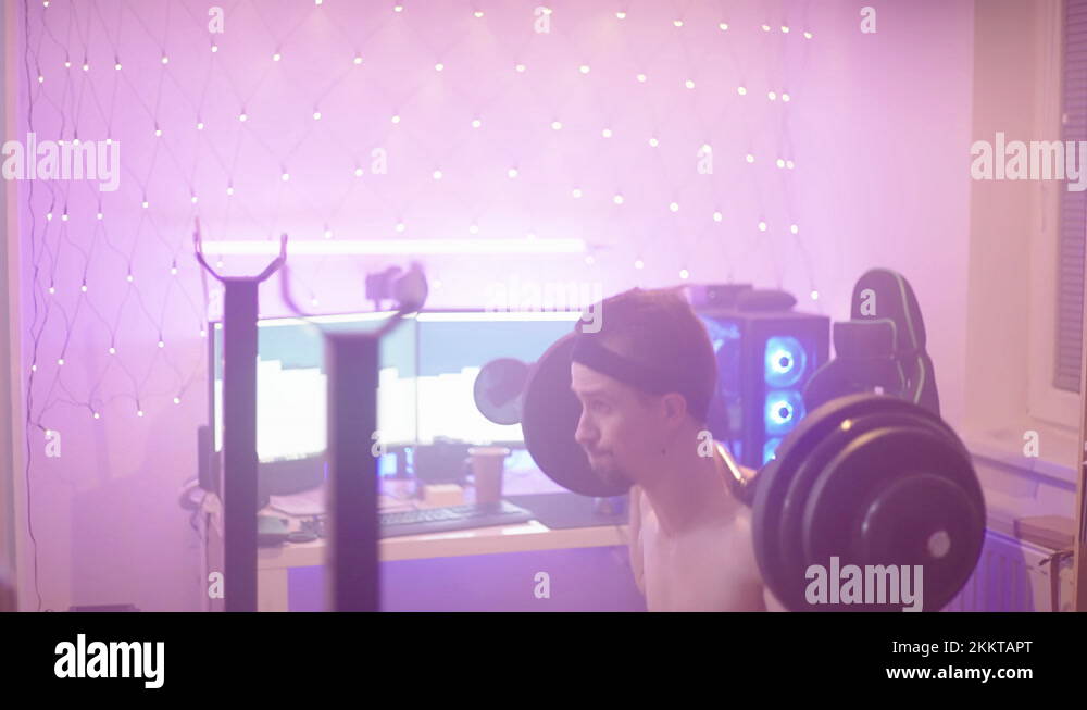 Male gamer in gaming room doing leg exercise with heavy barbell 4K ...