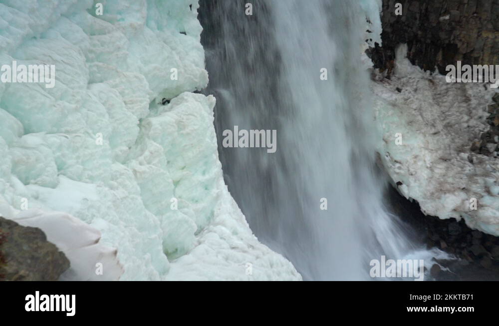 Water Cascading Through Icy Basalt Column Cliff. Svodufoss Waterfall In ...