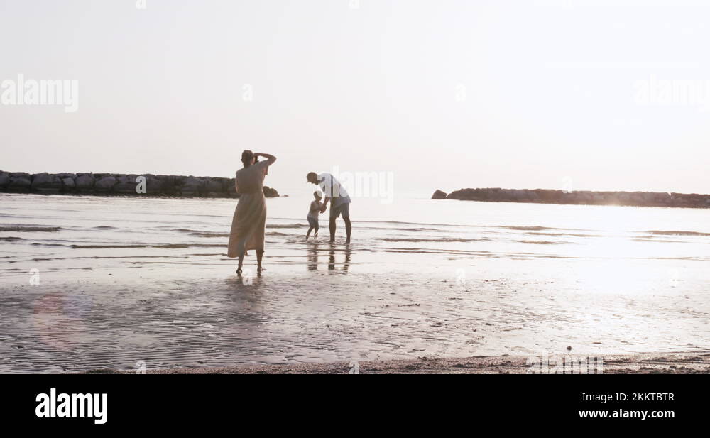 Wide shot, young photographer woman taking pictures of dad and son ...