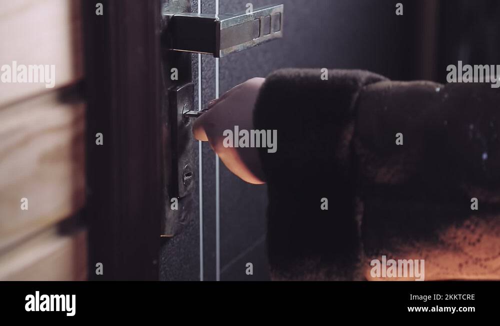 a woman's hand inserts the key into the keyhole turns unlocks the door ...