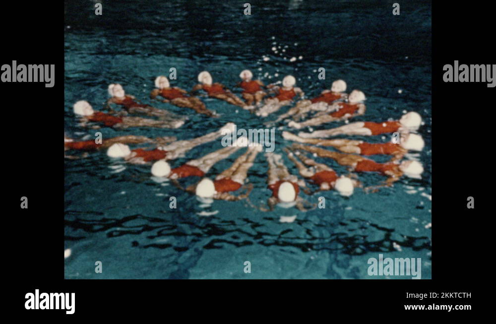 1950s: Kids in pool do synchronized swimming. Girl jumps from high dive ...
