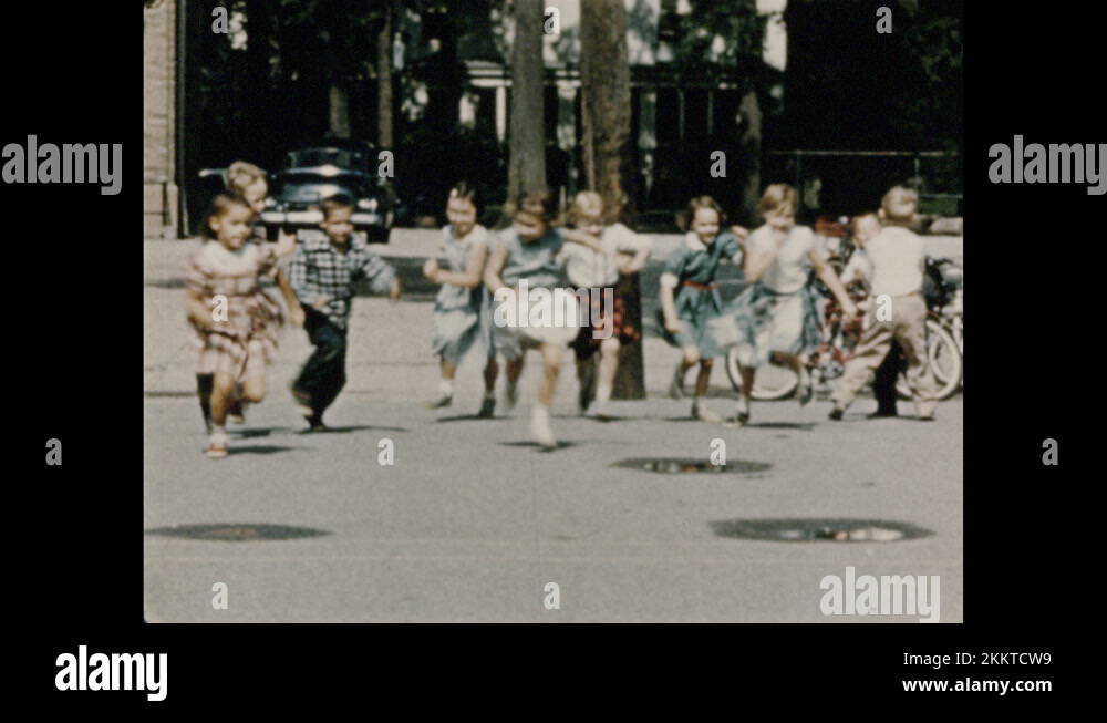1950s: Children run across playground. Children run in circle in gym ...